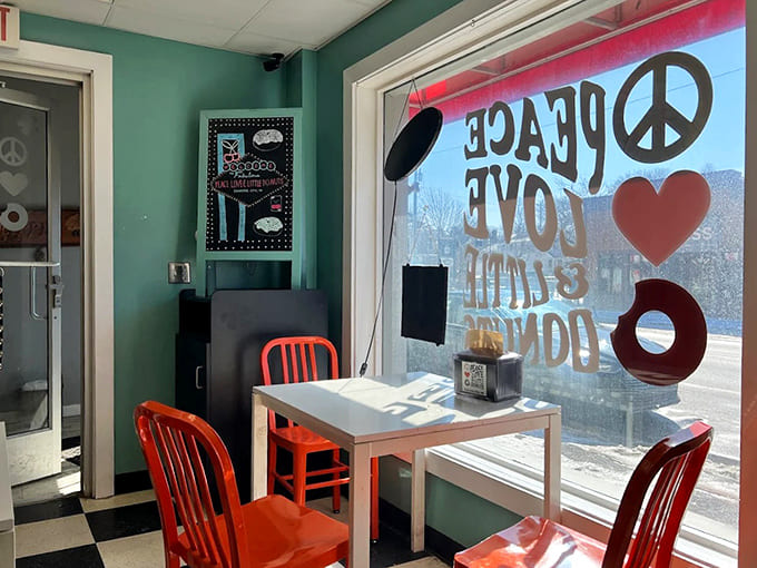 Turquoise walls and bright orange chairs create a retro vibe inside, where the window proudly displays the shop's peace-loving philosophy.