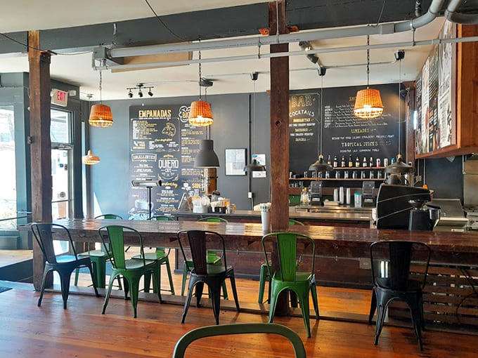 Step inside to discover a space where industrial chic meets tropical warmth, complete with cheerful green chairs that practically beg you to sit.