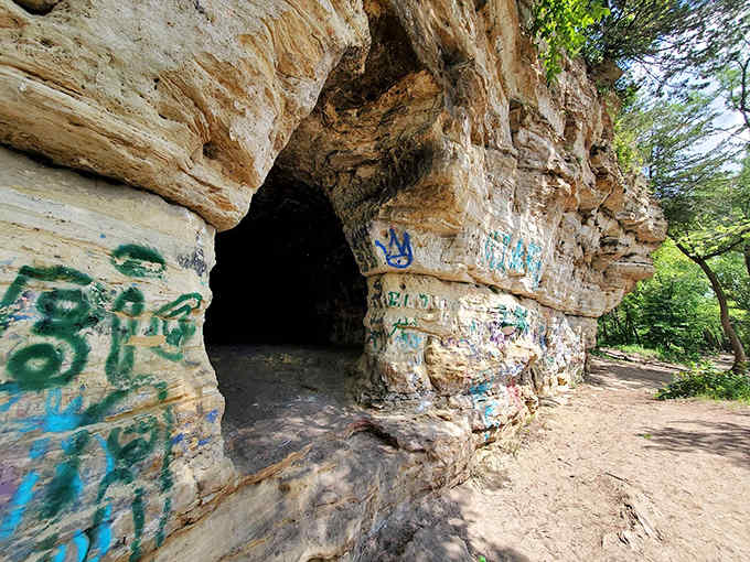 Nature's graffiti gallery welcomes explorers into its limestone embrace, where shadows dance and adventures begin.