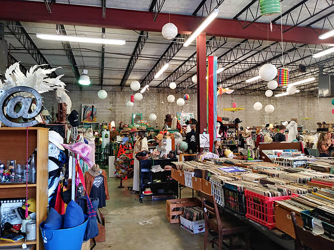 Treasure hunters navigate a wonderland of vintage finds under paper lanterns, where every aisle promises the thrill of unexpected discovery.