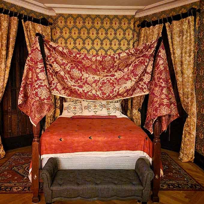 This Victorian bedroom setup makes modern minimalism look downright boring, with fabrics rich enough to bankrupt a small kingdom.