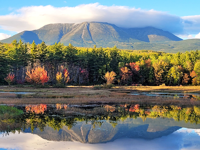 Fall's fiery palette transforms Katahdin's slopes into a painter's dream, doubling its glory in the still waters below.