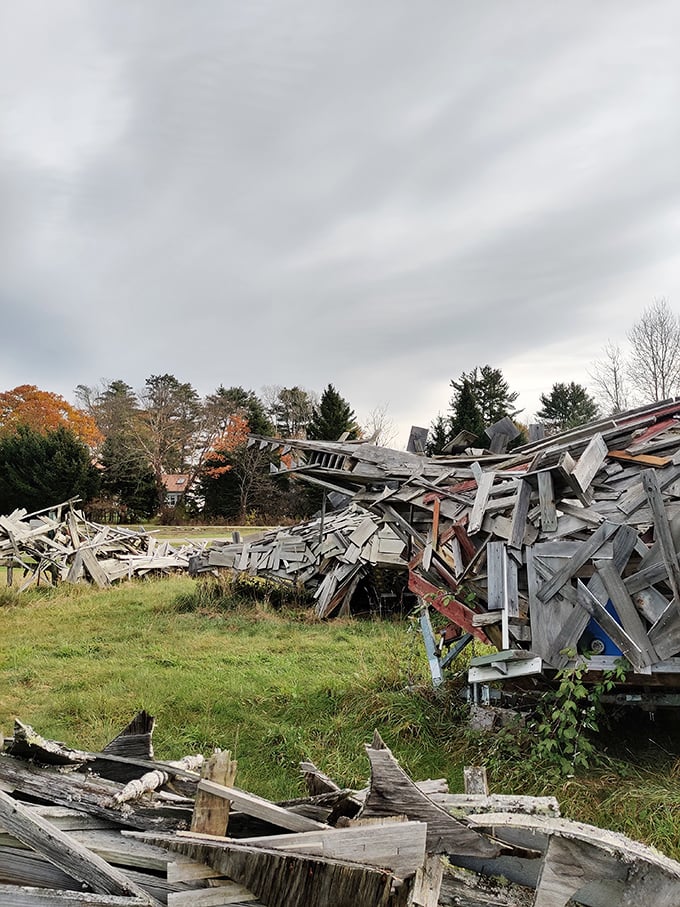 Weather-beaten planks create a prehistoric silhouette against rolling hills, showcasing Vermont's unique approach to recycling.