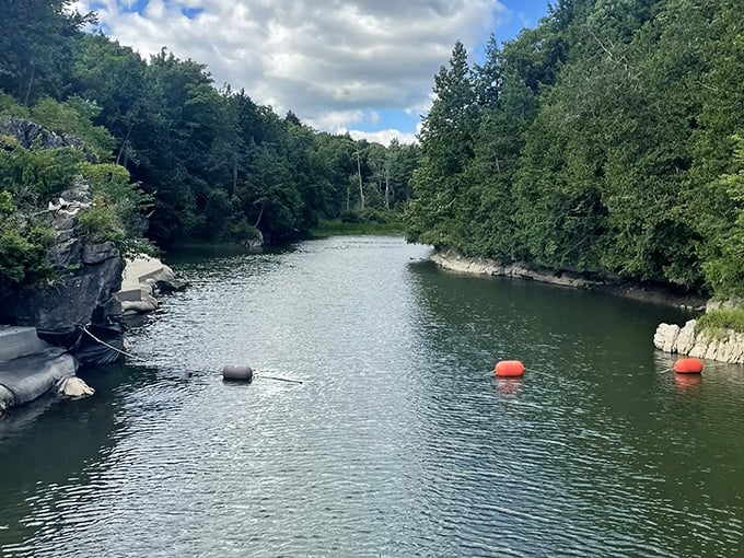 Crystal waters carve their ancient path through Vermont's wilderness, creating a serene swimming hole perfect for hot summer days.