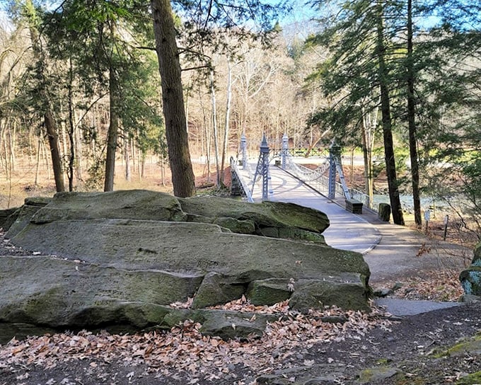 Nature meets architecture Massive stone foundations anchor the delicate bridge, while forest paths invite exploration beyond.