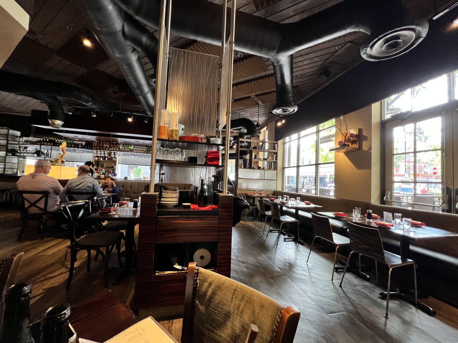 Dark wood meets industrial chic in this modern izakaya, where exposed ductwork and ambient lighting create the perfect backdrop for sushi adventures.