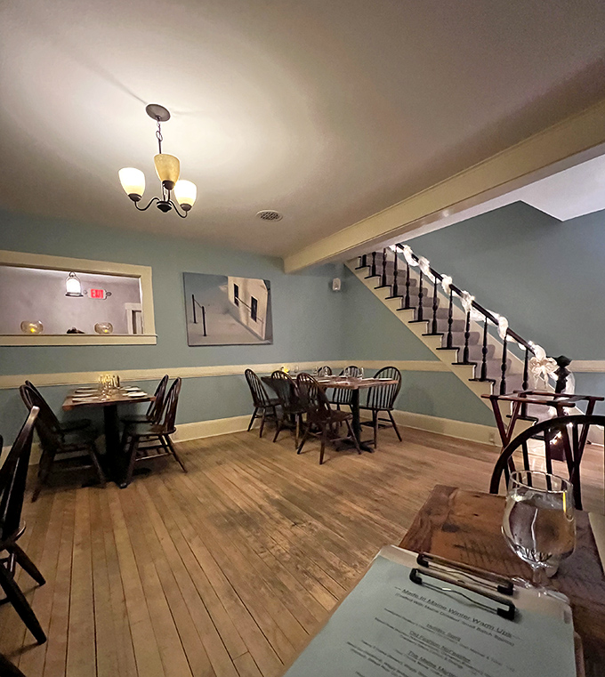 Soft blue walls and warm wooden floors create an atmosphere of casual elegance, where every table feels like the best seat in the house.