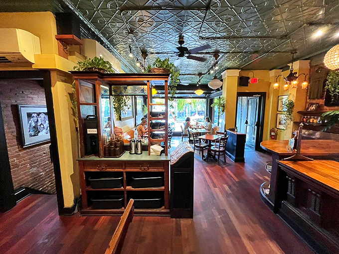 Warm wooden tables, exposed brick, and a pressed tin ceiling create the perfect backdrop for lingering conversations and memorable meals.