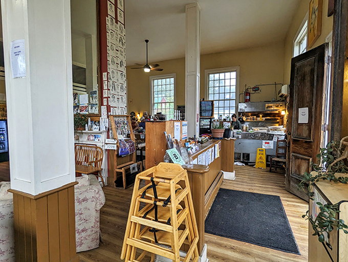 Step inside to discover a warm, inviting interior where mismatched furniture tells stories and the aroma of fresh coffee promises morning salvation.