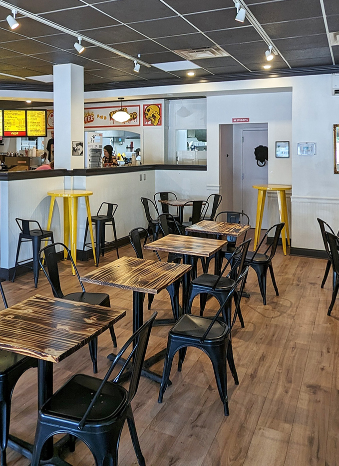 Modern minimalism meets cozy caf&eacute; charm in this thoughtfully designed interior, where black metal chairs and burnished wood tables create the perfect biscuit-enjoying environment.