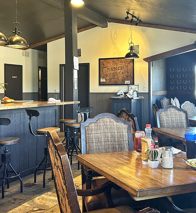 Rustic charm meets comfortable dining inside, where industrial pendant lights cast a warm glow over wooden tables and thoughtfully arranged seating.