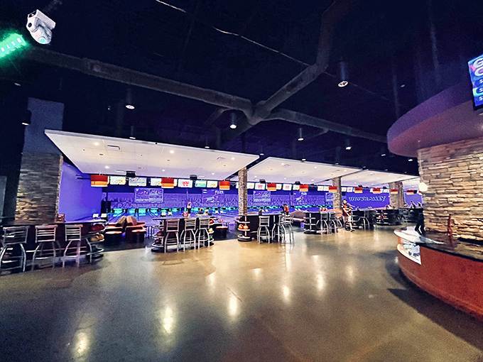The sleek interior bowling area glows with high-tech ambiance, where strikes and spares happen against a backdrop of music videos and sports action.