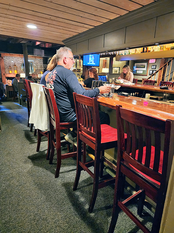 The warm, intimate bar area invites conversation and lingering, where locals and visitors alike gather to share stories over craft cocktails.