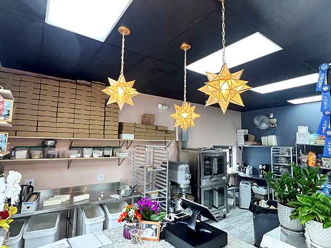 Star-shaped pendant lights cast a golden glow over the bakery workspace, where dessert dreams come to life in this compact sugar laboratory.