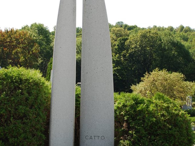 Twin granite pillars reach skyward, standing sentinel over the cemetery like modern-day obelisks guarding memories of lives well-lived.