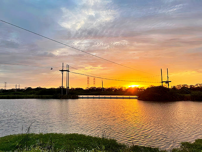 Nature's own light show paints the sky in golden hues as day surrenders to evening over the tranquil waters.