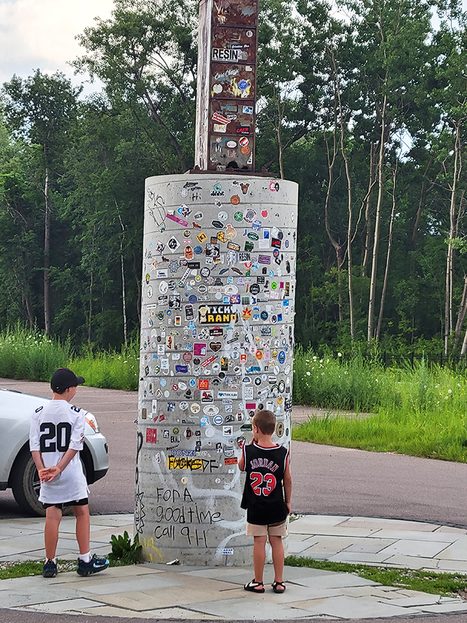 The concrete base serves as a community guestbook, plastered with stickers and graffiti from visitors marking their pilgrimage.