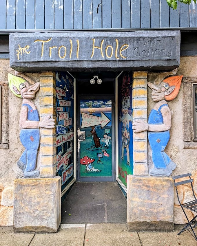 Two mischievous troll guardians flank the entrance to The Troll Hole Museum, their big ears and colorful outfits setting the whimsical tone for what awaits inside.