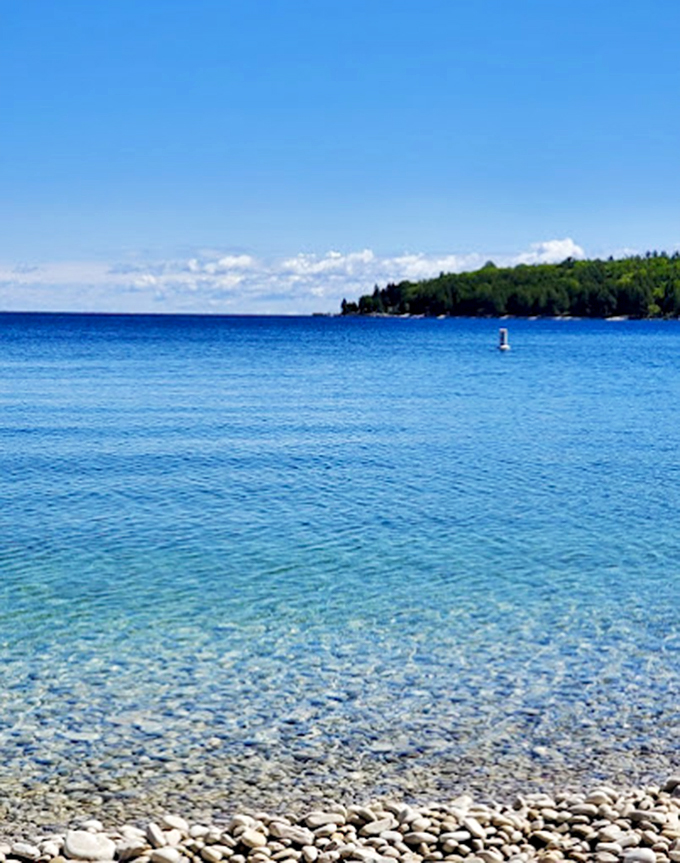 Crystal-clear waters meet a shore of perfectly round pebbles. It's like Mother Nature's own rock tumbler!