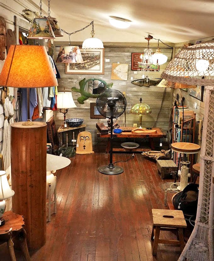 Weathered floorboards creak beneath your feet as maritime artifacts and vintage lamps transform this humble space into a captain's quarters of curiosities.