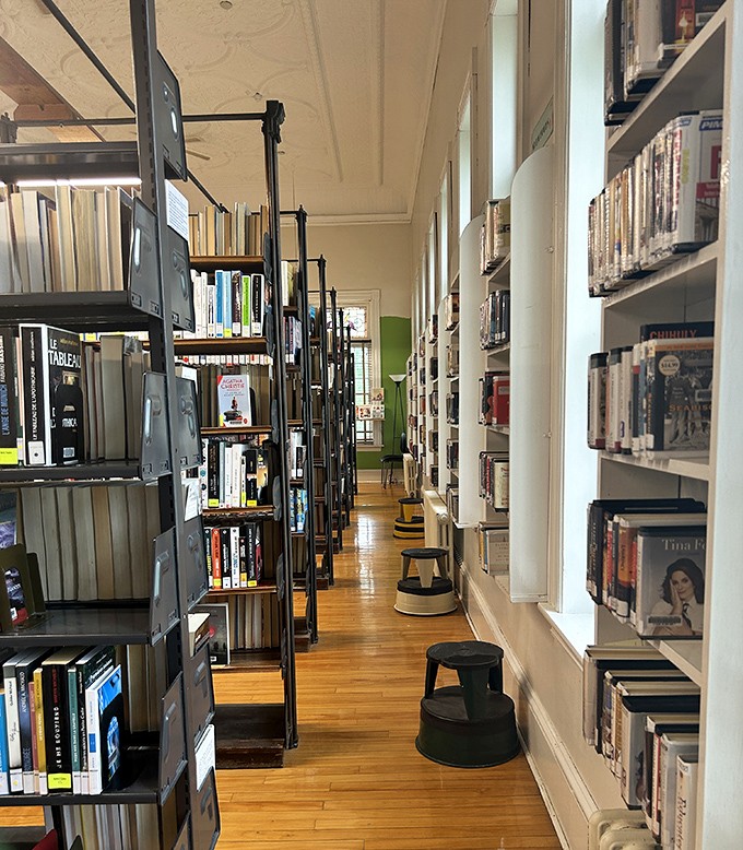 Bookshelves: Metal and wood stand sentinel, holding stories in two languages that whisper across borders to readers from both nations.