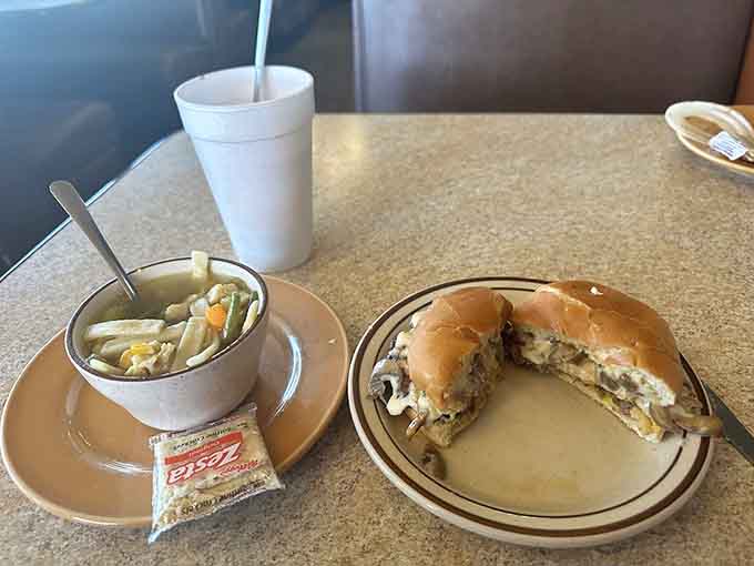 Behold the burger and its loyal companion, a bowl of soup, proving that sometimes the simplest combinations are the most satisfying.