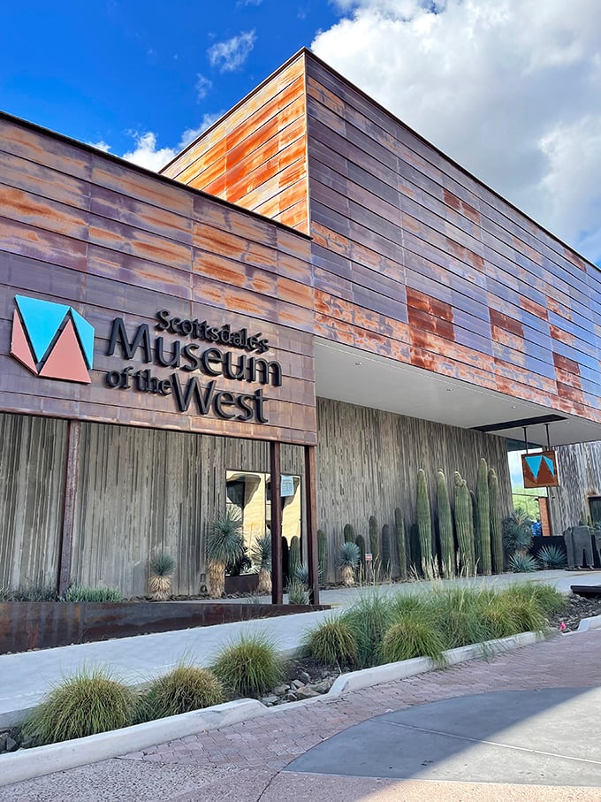 Desert plants frame the entrance, offering visitors a taste of authentic Sonoran landscape before the indoor journey begins.