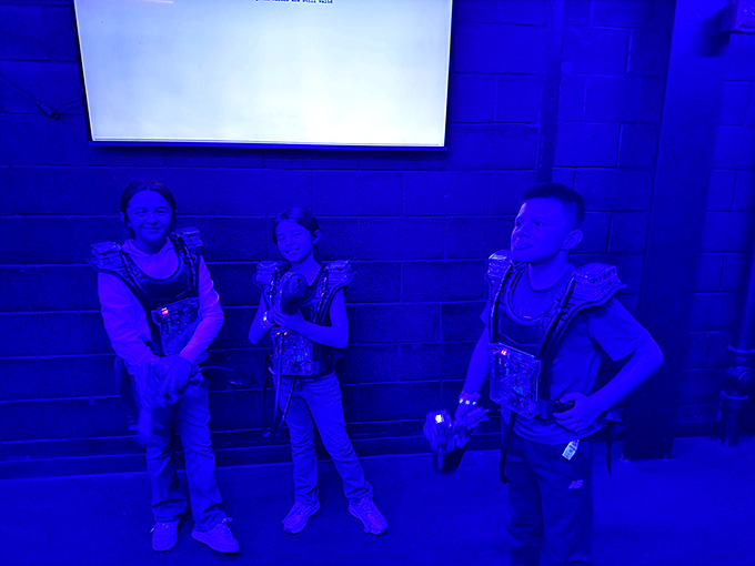 Laser tag warriors strategize their next move, proving that in the blue-lit battlefield, accountants and third-graders become equals.