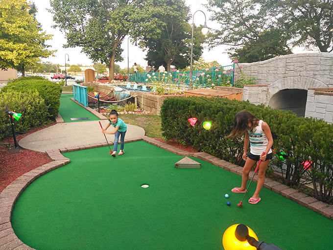 Young putters concentrate on their shots, navigating the colorful course with determination that would make Tiger Woods proud.