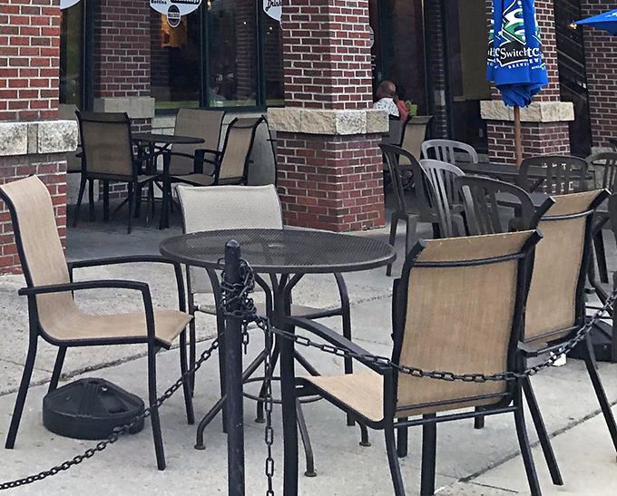 Fresh air dining meets classic brick architecture, where comfortable patio furniture invites you to linger over lunch or dinner.