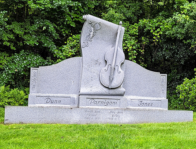 Music lives forever in this violin-adorned headstone for the Parnigoni family, where granite strings seem to vibrate with silent melodies.