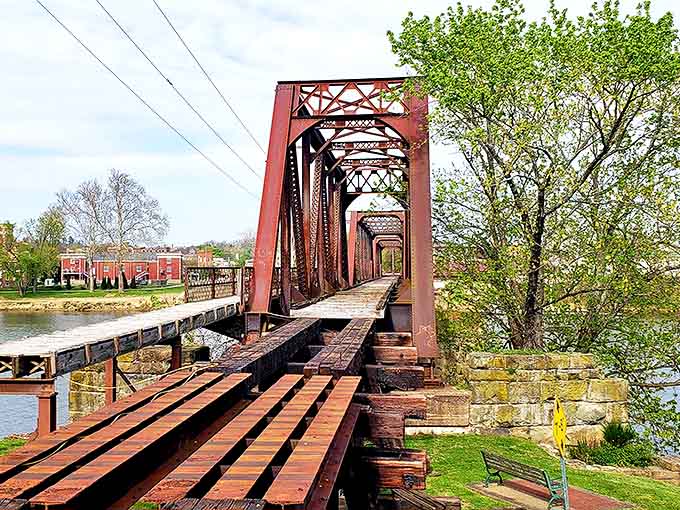 The old railway bridge stretches across the Muskingum River like an industrial sculpture, each iron beam telling stories of commerce past.