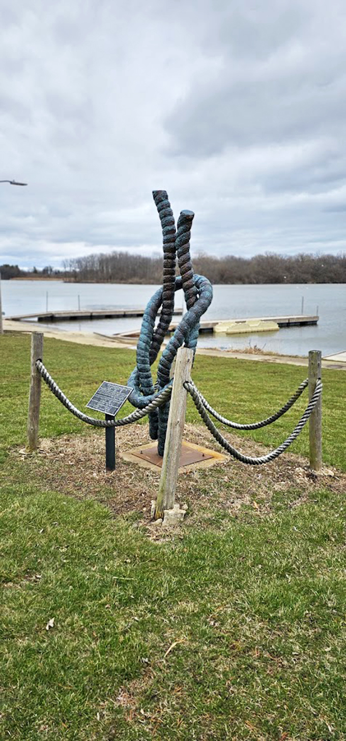 Against a moody winter sky, the knot stands sentinel over the lake, its twisted form creating an unexpected lakeside landmark. 