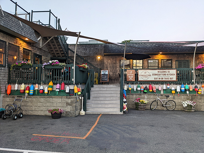 Stonecutters Kitchen welcomes diners with colorful buoys and flower boxes, promising authentic Maine flavors in a casual atmosphere.