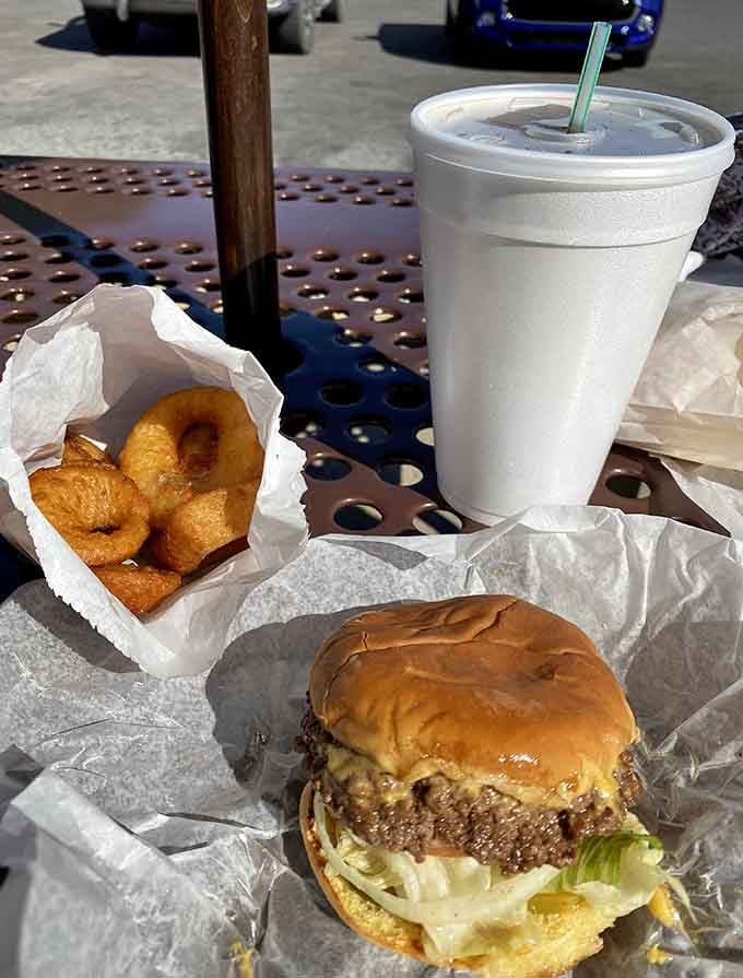 That double cheeseburger paired with golden onion rings represents everything right about American drive-in culture in one glorious basket.