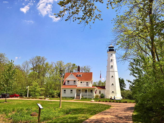 A postcard-perfect scene: North Point Lighthouse stands tall, its white tower a beacon of history against the vibrant blue sky. Pure Wisconsin magic!