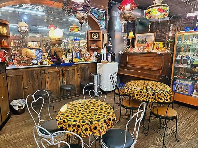 Vintage lamps cast a warm glow over cozy caf&eacute; tables, creating the perfect spot for weary shoppers to rest and compare their newfound treasures.