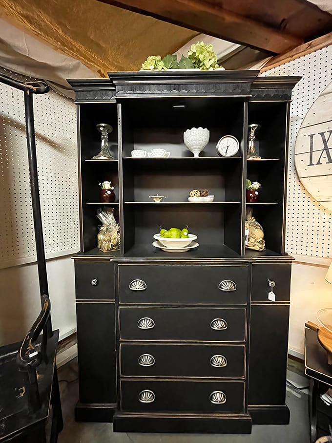 Stately black cabinetry with gleaming hardware offers both storage and display space &ndash; the perfect marriage of function and vintage elegance.