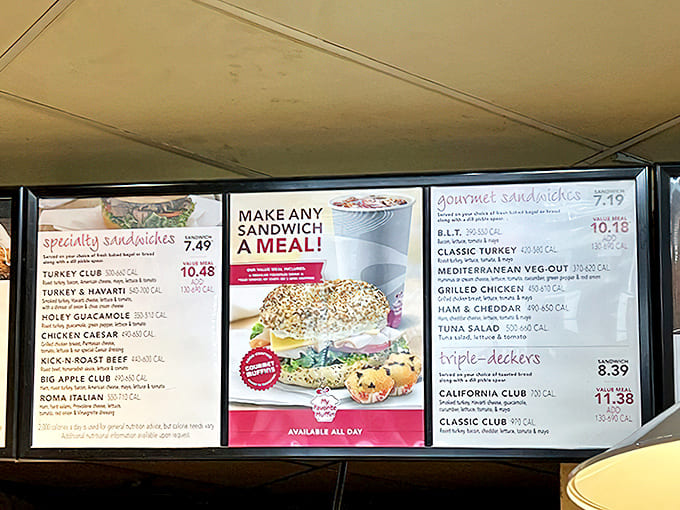 The menu board reveals a sandwich lineup that transforms morning bagels into all-day affairs, from classic turkey to Mediterranean veggie options.
