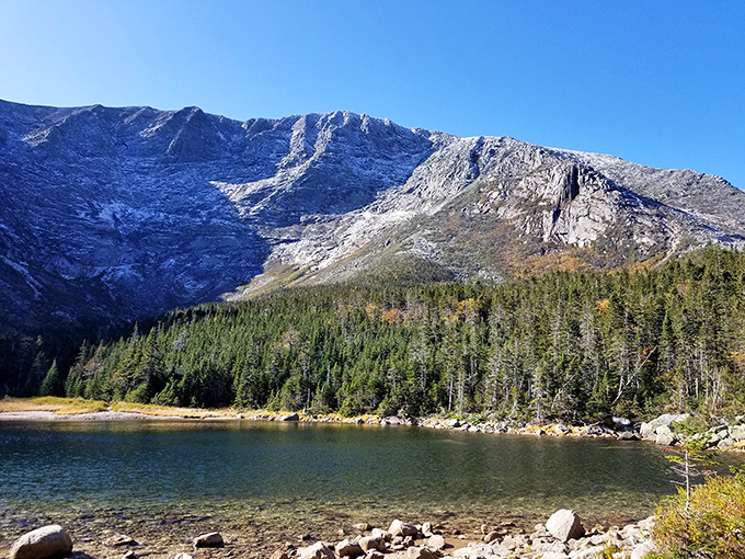 Sunlight plays across Chimney Pond's crystal waters, revealing a geological masterpiece millions of years in the making.