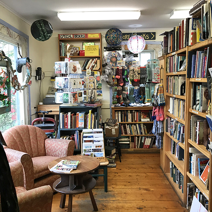 A cozy reading nook invites literary explorers to sink into cushioned comfort, surrounded by thousands of potential adventures bound in paper and ink.