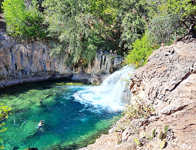 The reward after the hike: Visitors cool off in the refreshing 70-degree waters while the waterfall provides nature's soundtrack.