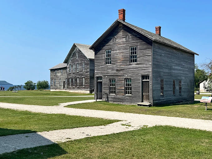 Weather-worn wooden houses stand in stoic formation, their weathered facades whispering tales of families who once called this company town home.