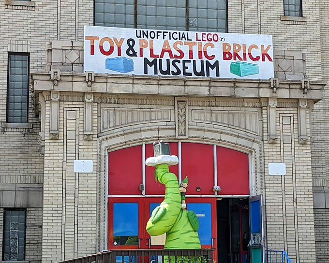 Housed in a former school building, the Bellaire Toy & Plastic Brick Museum welcomes LEGO enthusiasts with its colorful banner and playful dinosaur mascot standing watch.