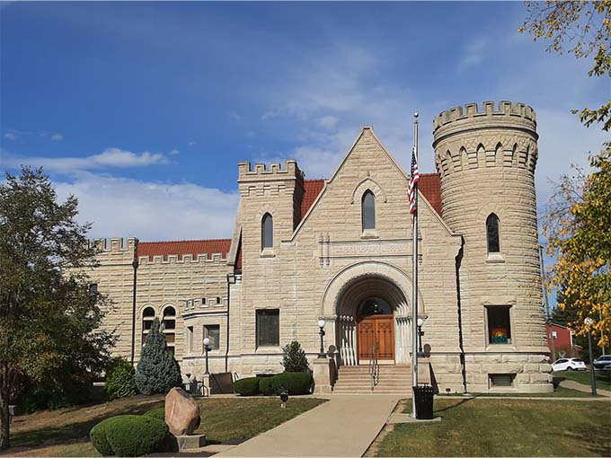 Sunlight highlights the library's impressive stonework and architectural details, making this Van Wert landmark look like it belongs in a European village.