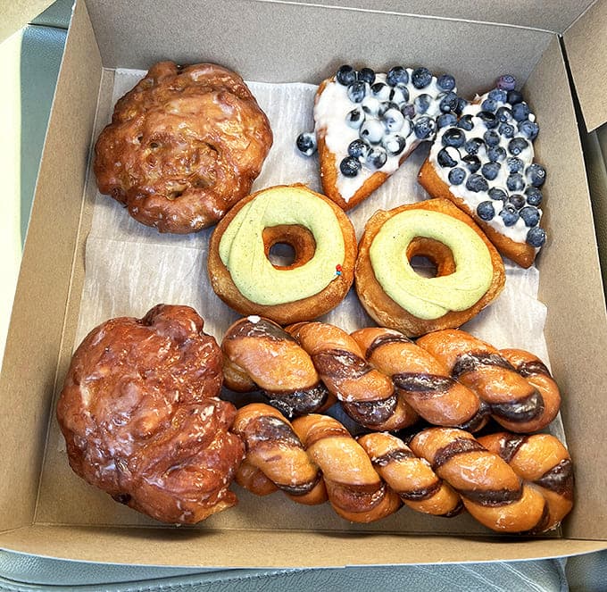 Apple fritters and blueberry-topped donuts nestled together like edible works of art &ndash; proof that sometimes the most beautiful things in life are also the most delicious.