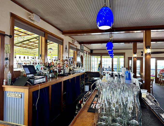 Blue pendant lights dance above a well-stocked bar, where the "Beware of Attack Lobster" sign sets the playful tone.