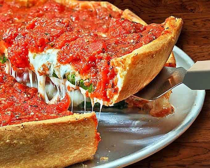 Behold the deep dish in all its glory, a towering masterpiece of crust, cheese, and toppings that requires a fork, knife, and serious appetite.