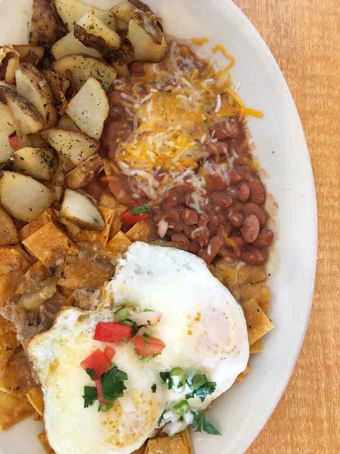 Chilaquiles done right: crispy chips, rich sauce, perfectly cooked eggs, and enough cheese to make you reconsider your life choices.