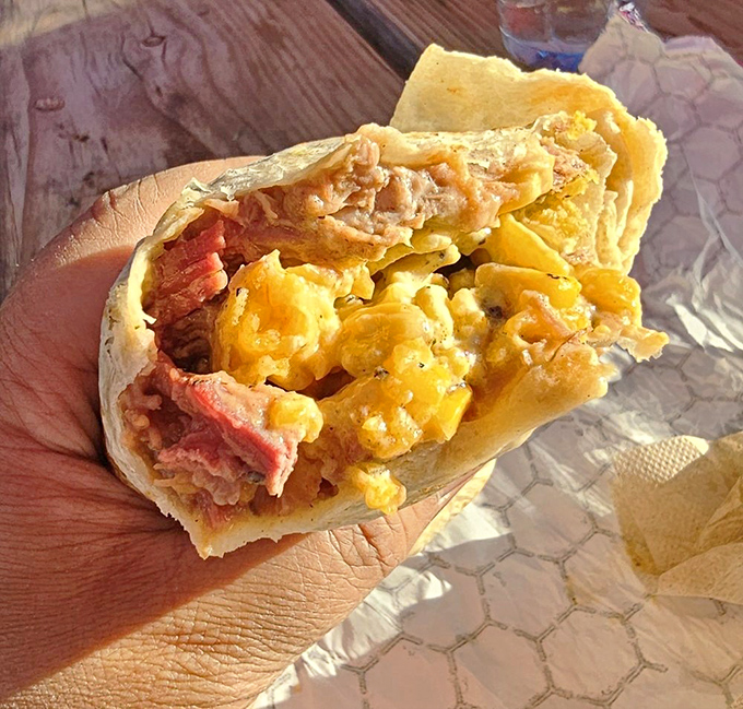 Breakfast of champions: a perfectly wrapped brisket burrito revealing its treasure of smoky meat and melty cheese.